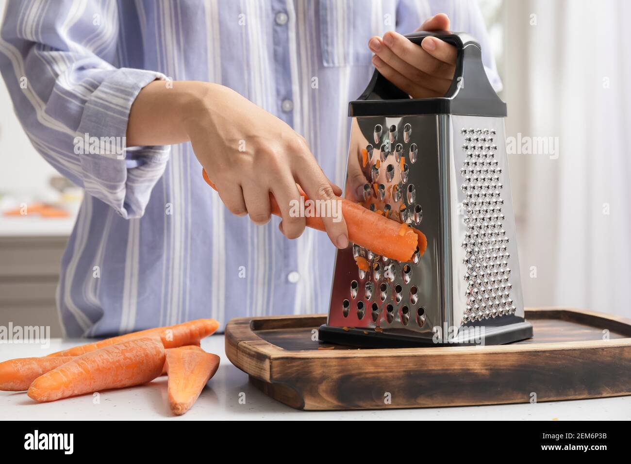 Woman grating carrots in kitchen hi-res stock photography and images - Alamy