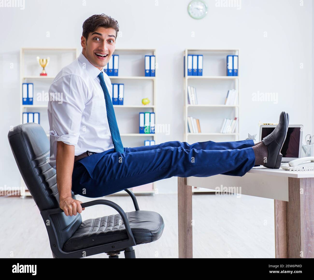 The young businessman doing sports stretching at workplace Stock Photo ...