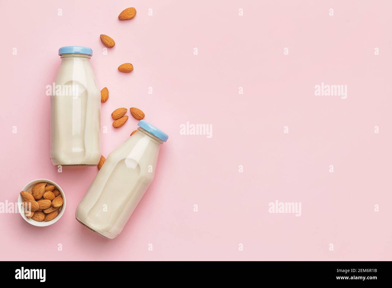 Bottles of tasty almond milk on color background Stock Photo - Alamy