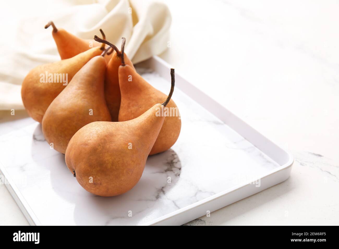 Tray with fresh ripe pears on light background Stock Photo - Alamy
