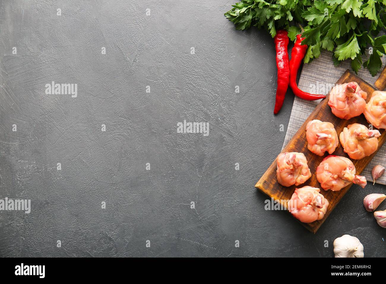 Board with raw chicken lollipops on dark background Stock Photo - Alamy