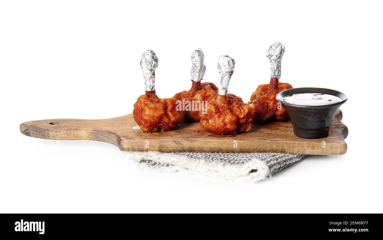 Board with tasty chicken lollipops and sauce on white background Stock ...