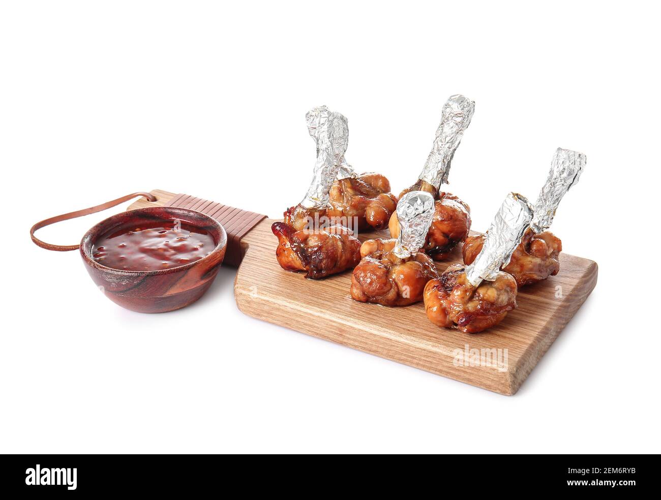 Board with tasty chicken lollipops and sauce on white background Stock ...