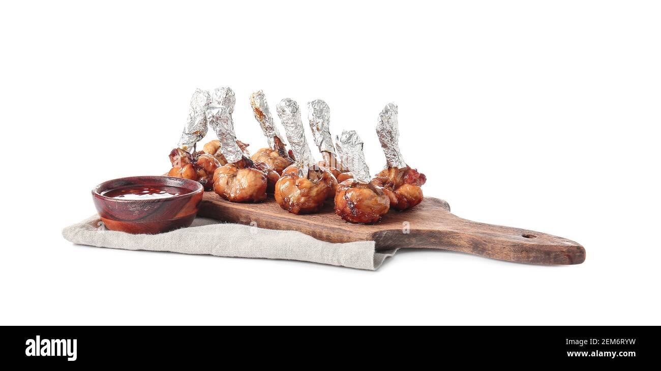 Board with tasty chicken lollipops and sauce on white background Stock ...