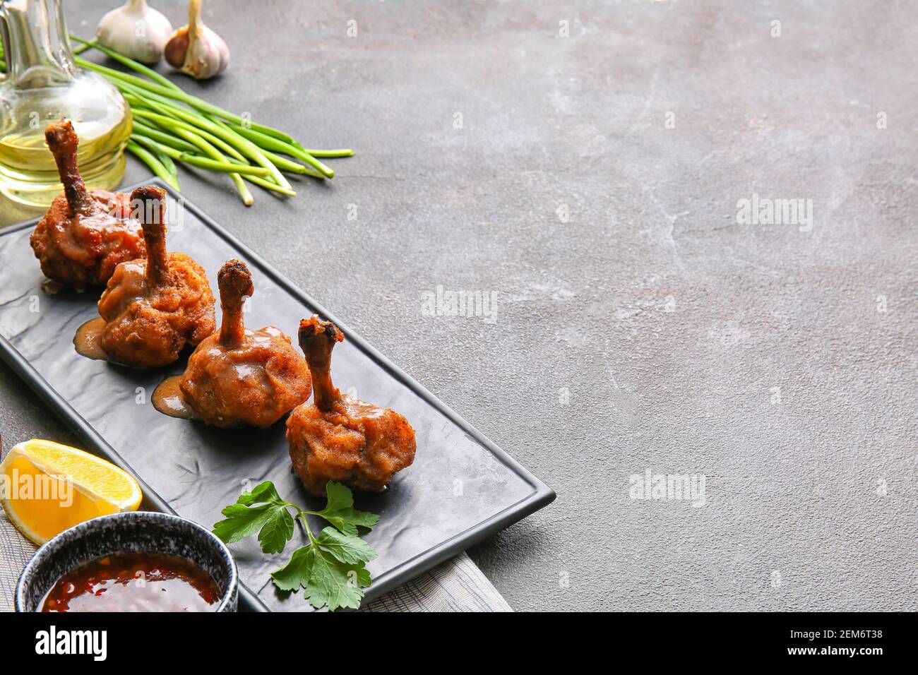 Board with tasty chicken lollipops on dark background Stock Photo - Alamy
