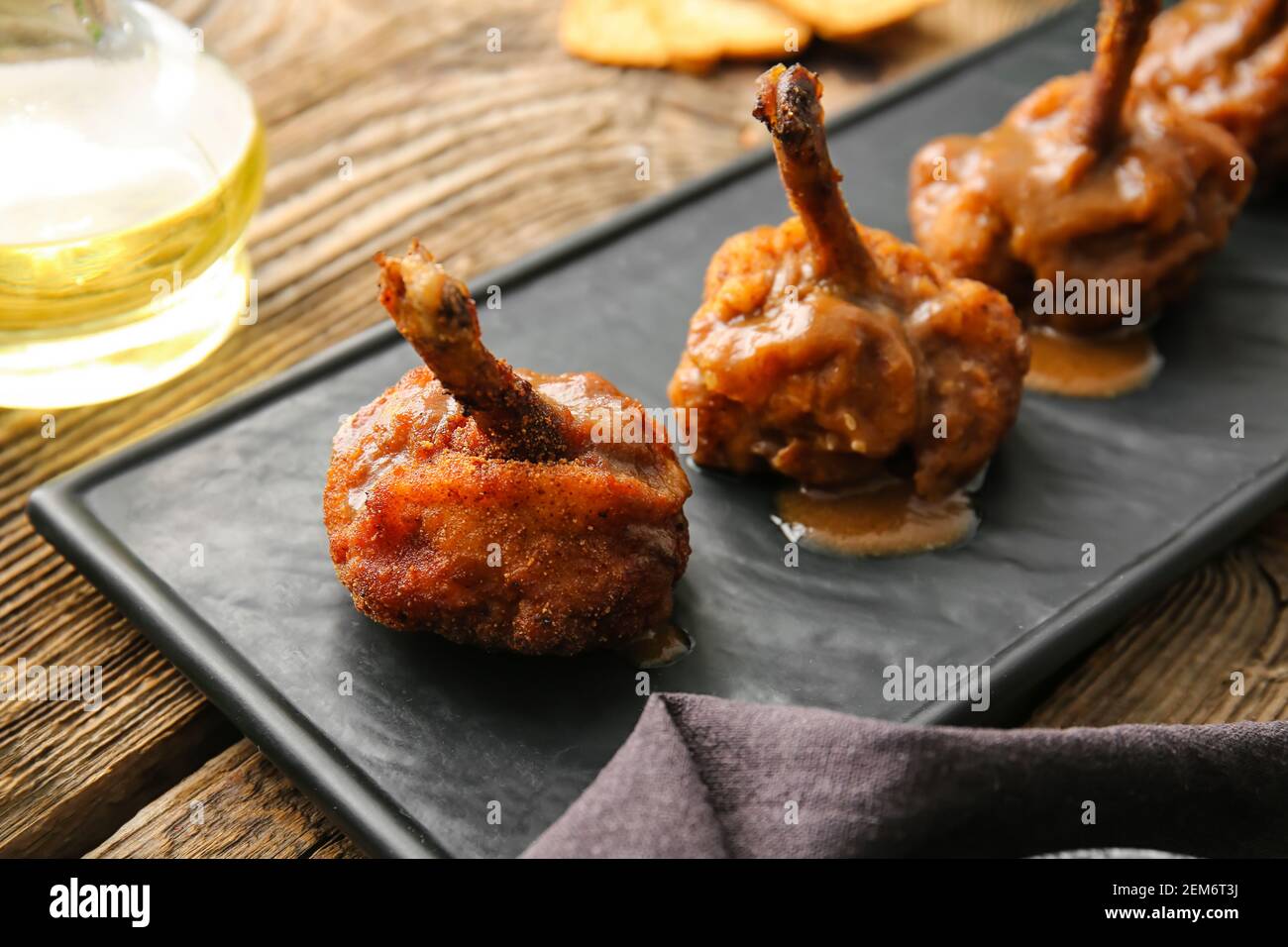 Board with tasty chicken lollipops on wooden background Stock Photo - Alamy