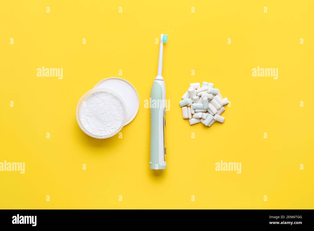 Chewing gums, electric toothbrush and tooth powder on color background ...