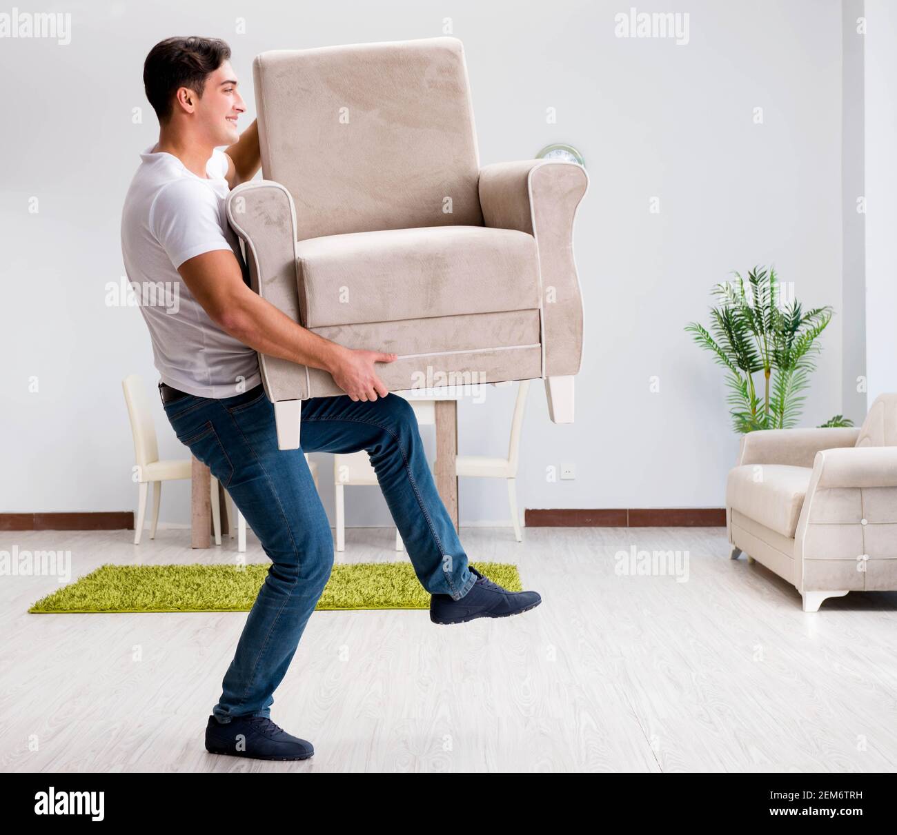 The young man moving furniture at home Stock Photo - Alamy