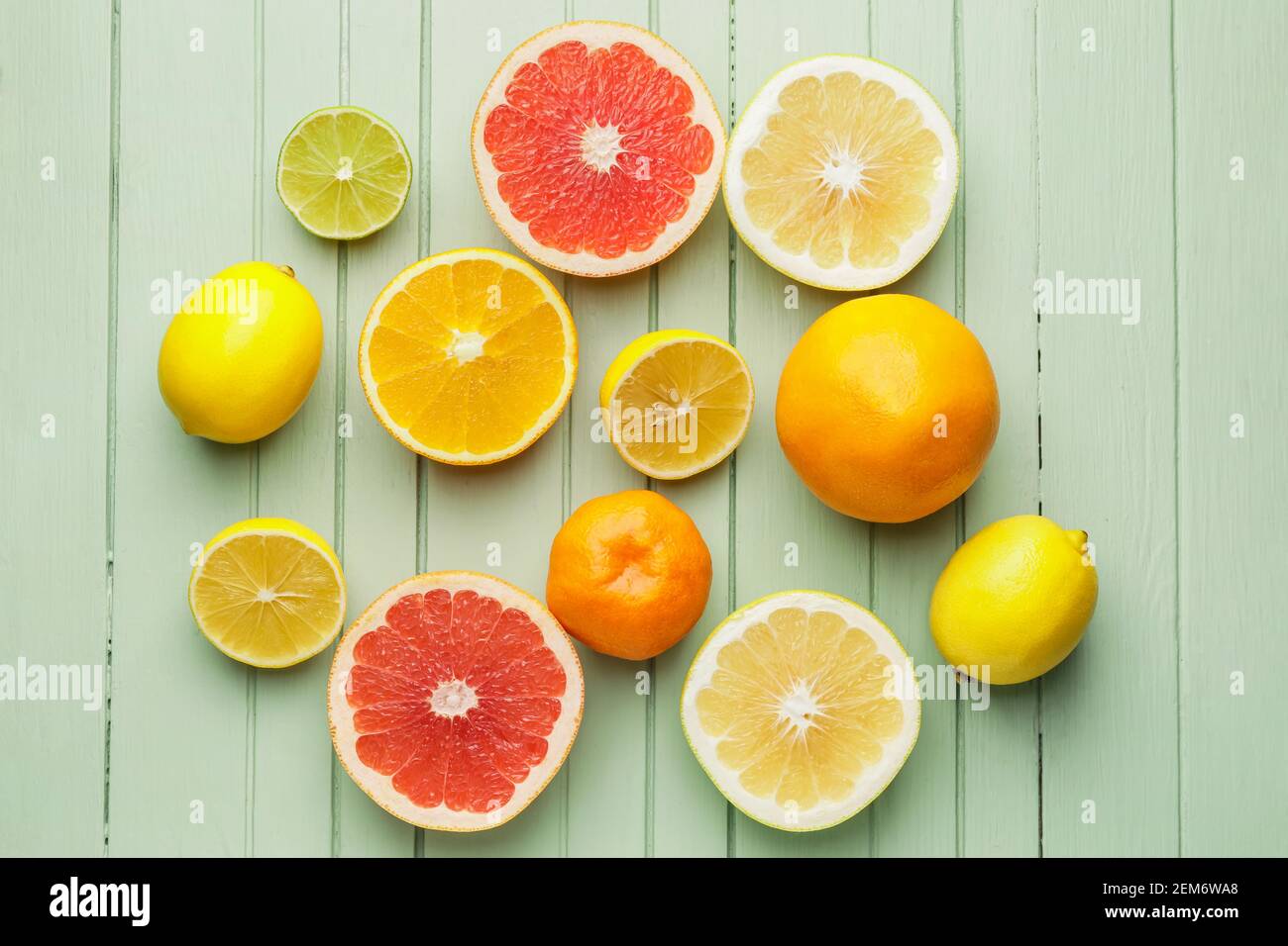 Cut citrus fruits on color wooden background Stock Photo - Alamy