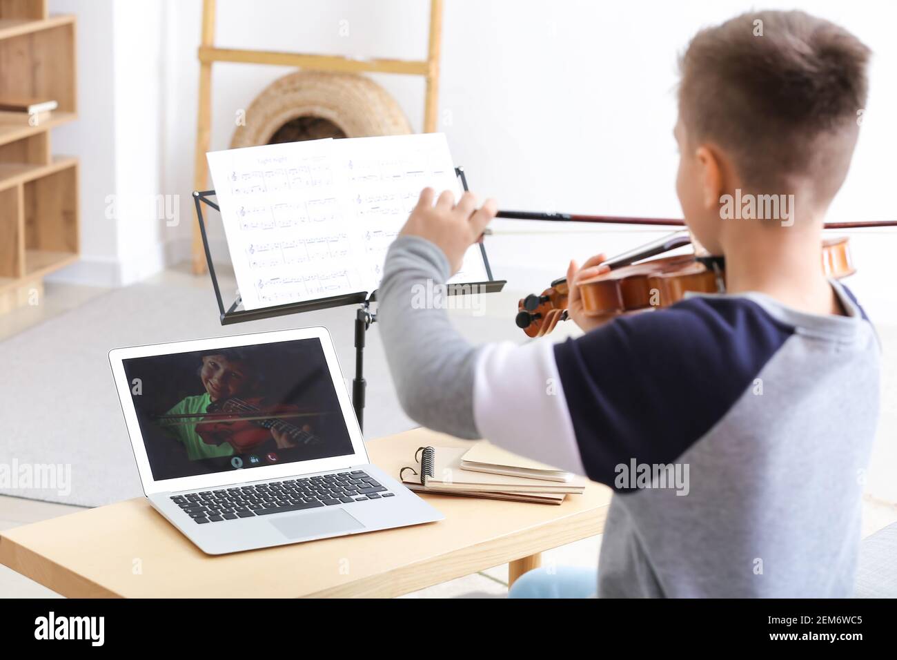 Little boy taking music lessons online at home Stock Photo - Alamy