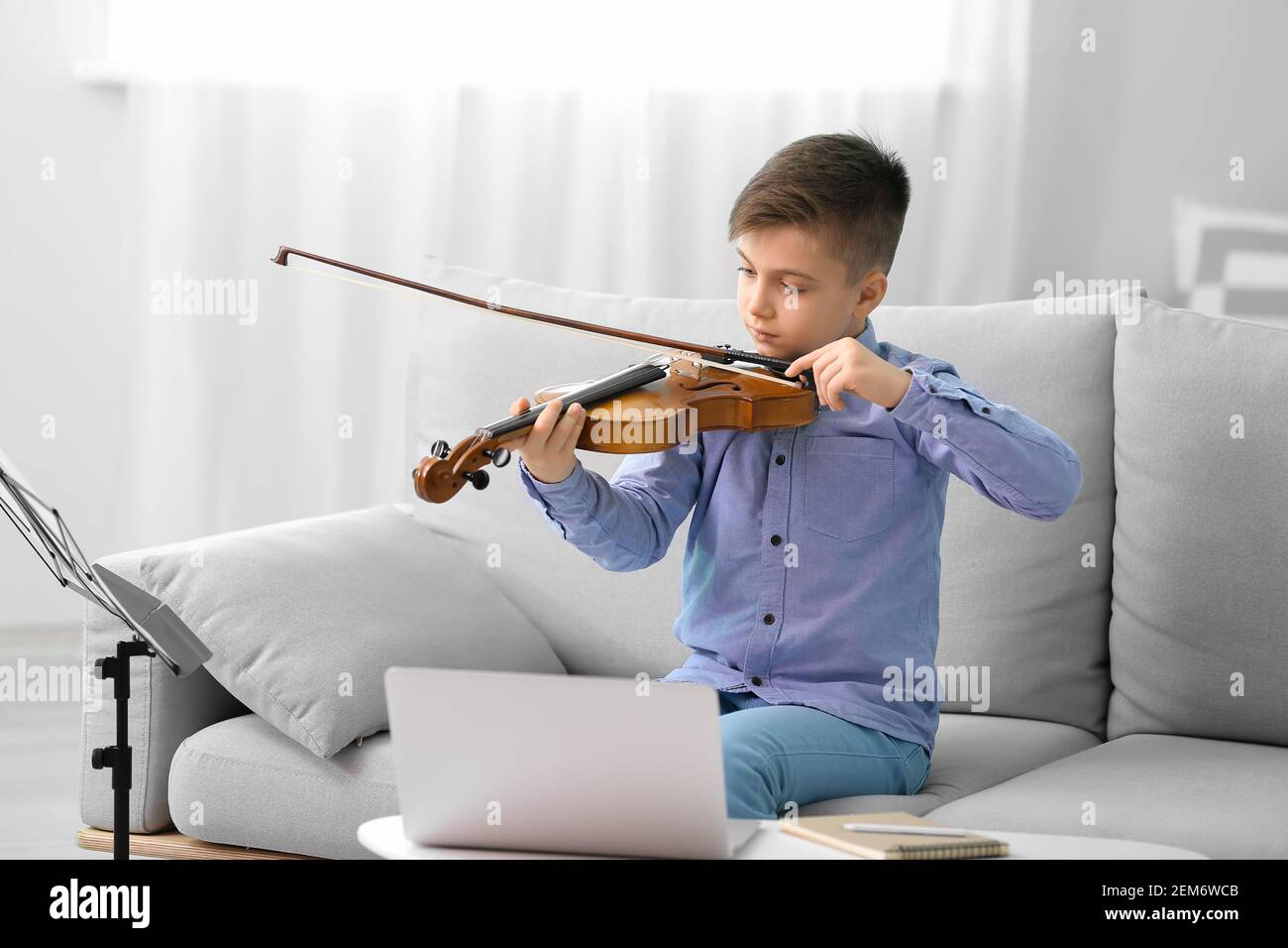 Little boy taking music lessons online at home Stock Photo - Alamy