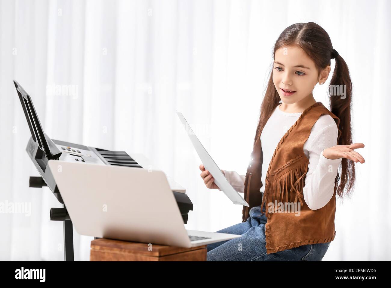 Little girl taking music lessons online at home Stock Photo - Alamy