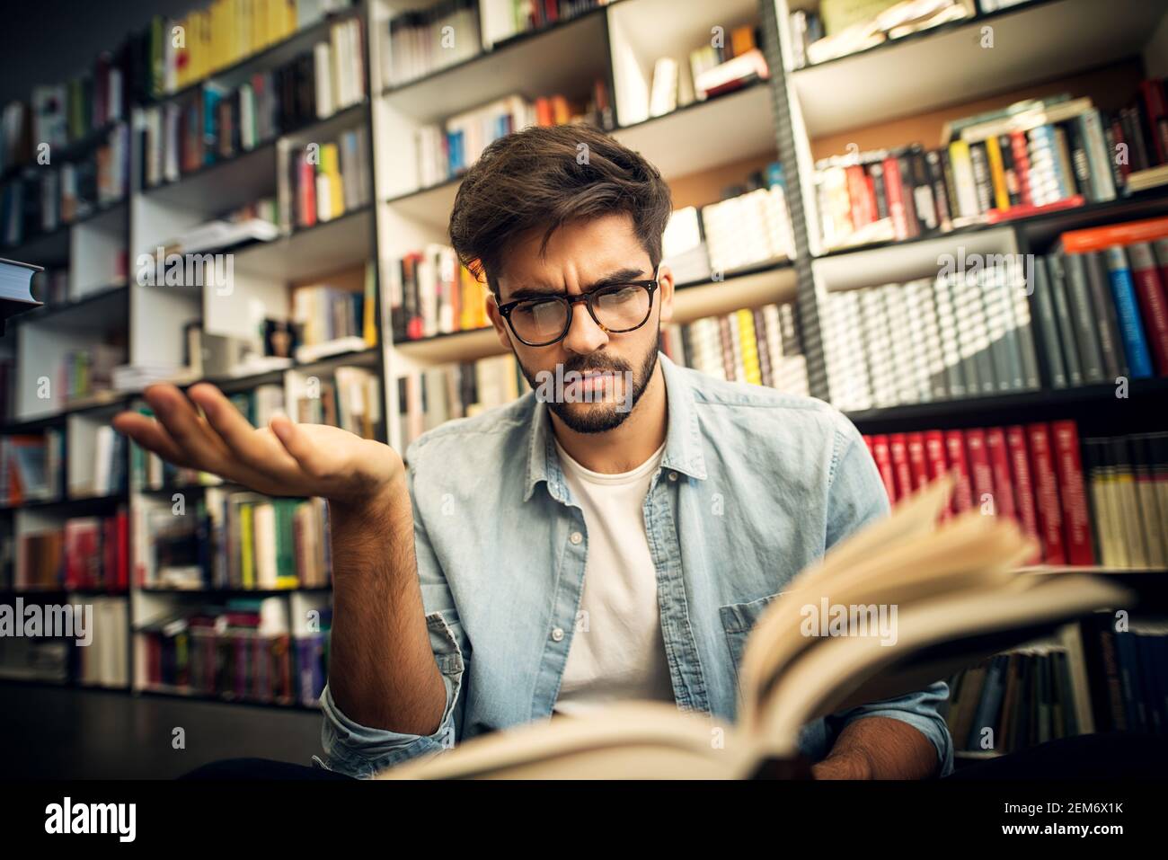 Confused young male student does not understand the contents of the ...