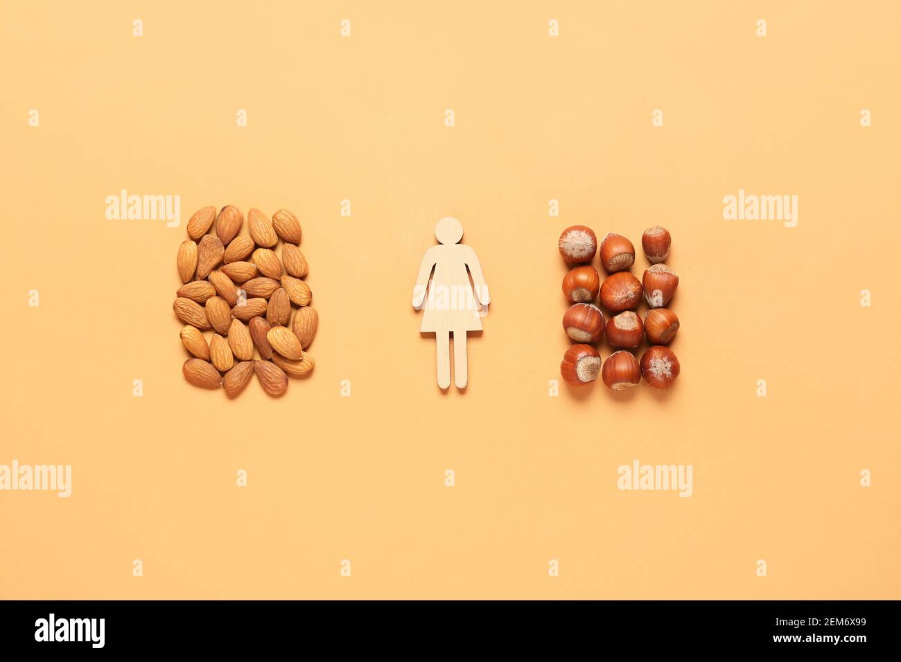Different healthy nuts and female figure on color background Stock ...