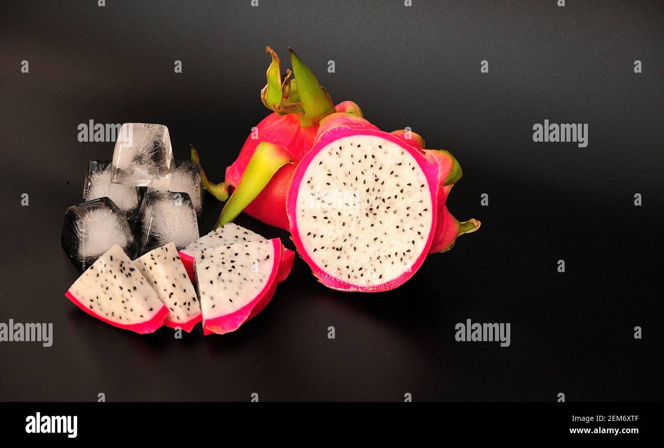 Ripe cut fruit of exotic fruit Pitaya or Dragon Heart with ice cubes on ...