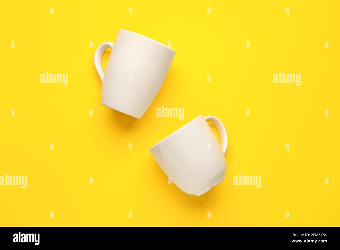 Empty cups on color background Stock Photo - Alamy