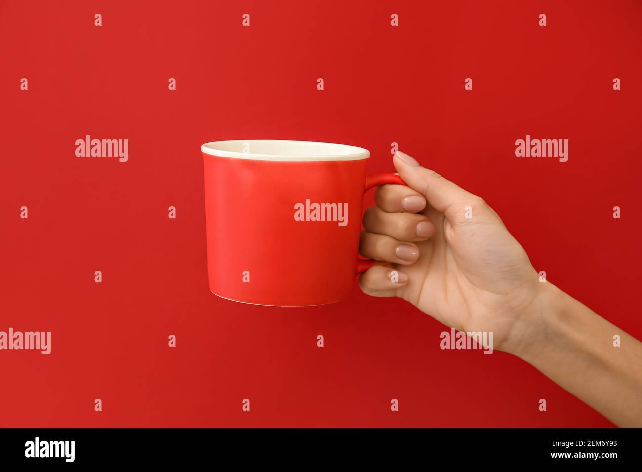 Hand with cup on color background Stock Photo - Alamy