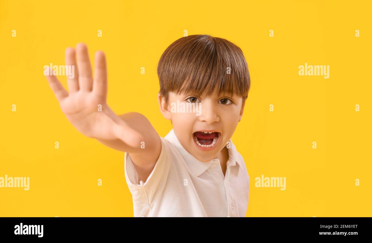 Cute little boy waving hand on color background Stock Photo - Alamy