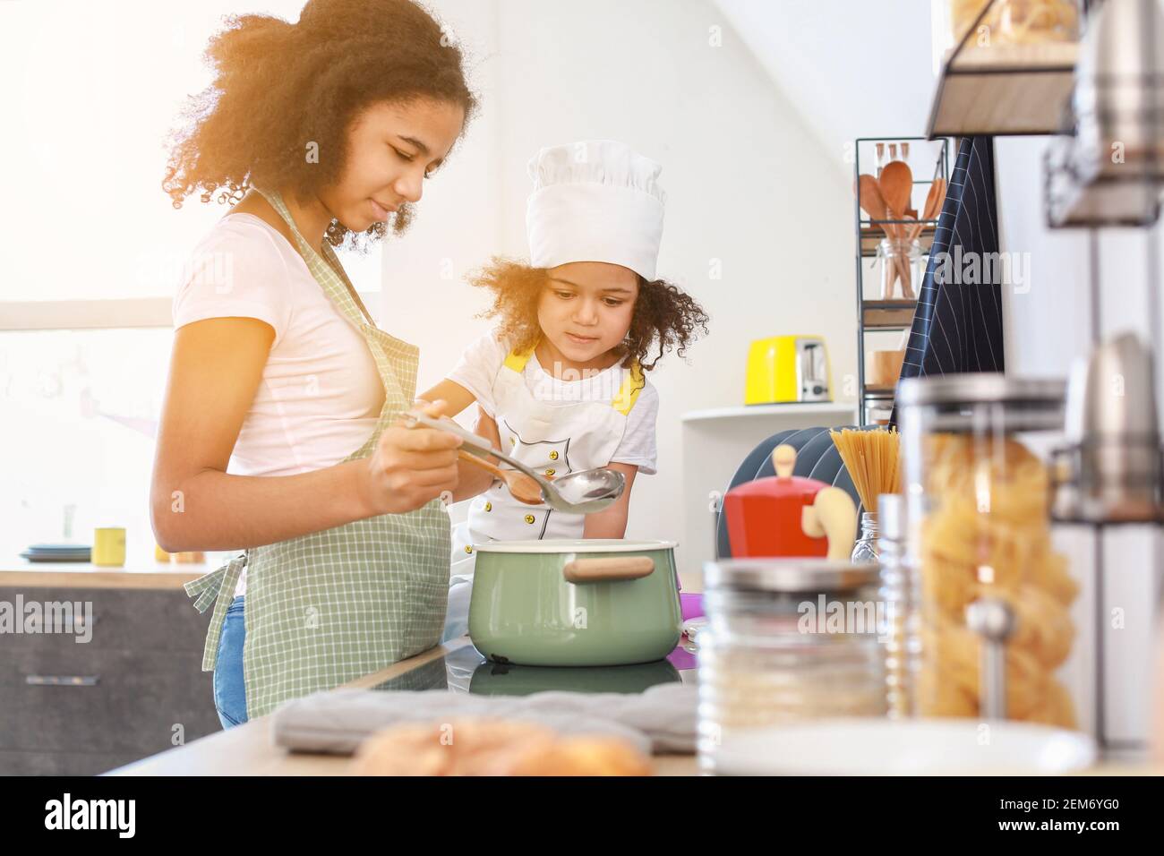 Cute African-American sisters cooking in kitchen Stock Photo - Alamy