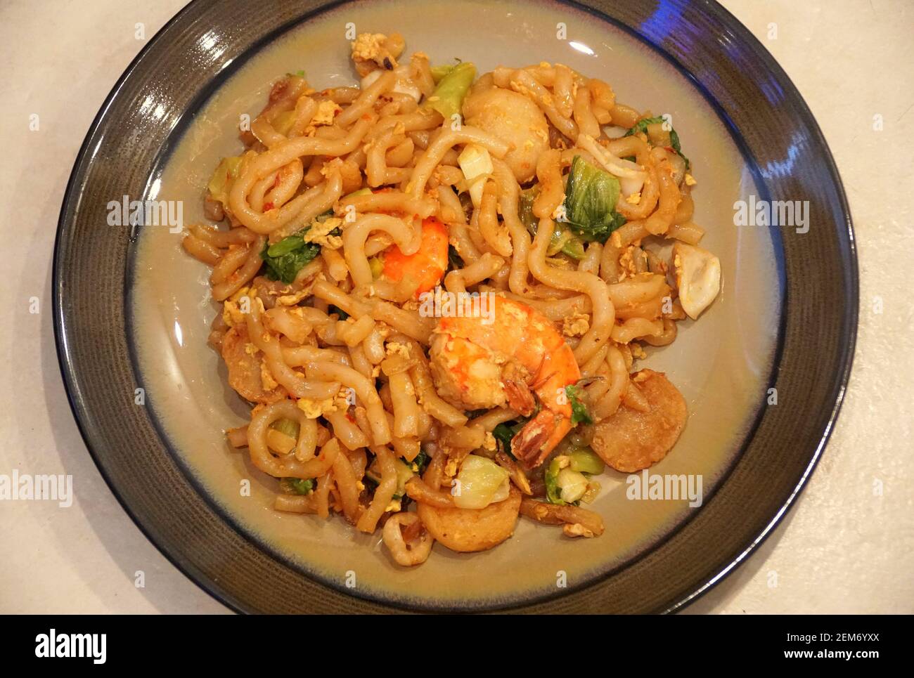 Fried tapioca rice noodle with shrimp and fish balls on a ceramic plate ...