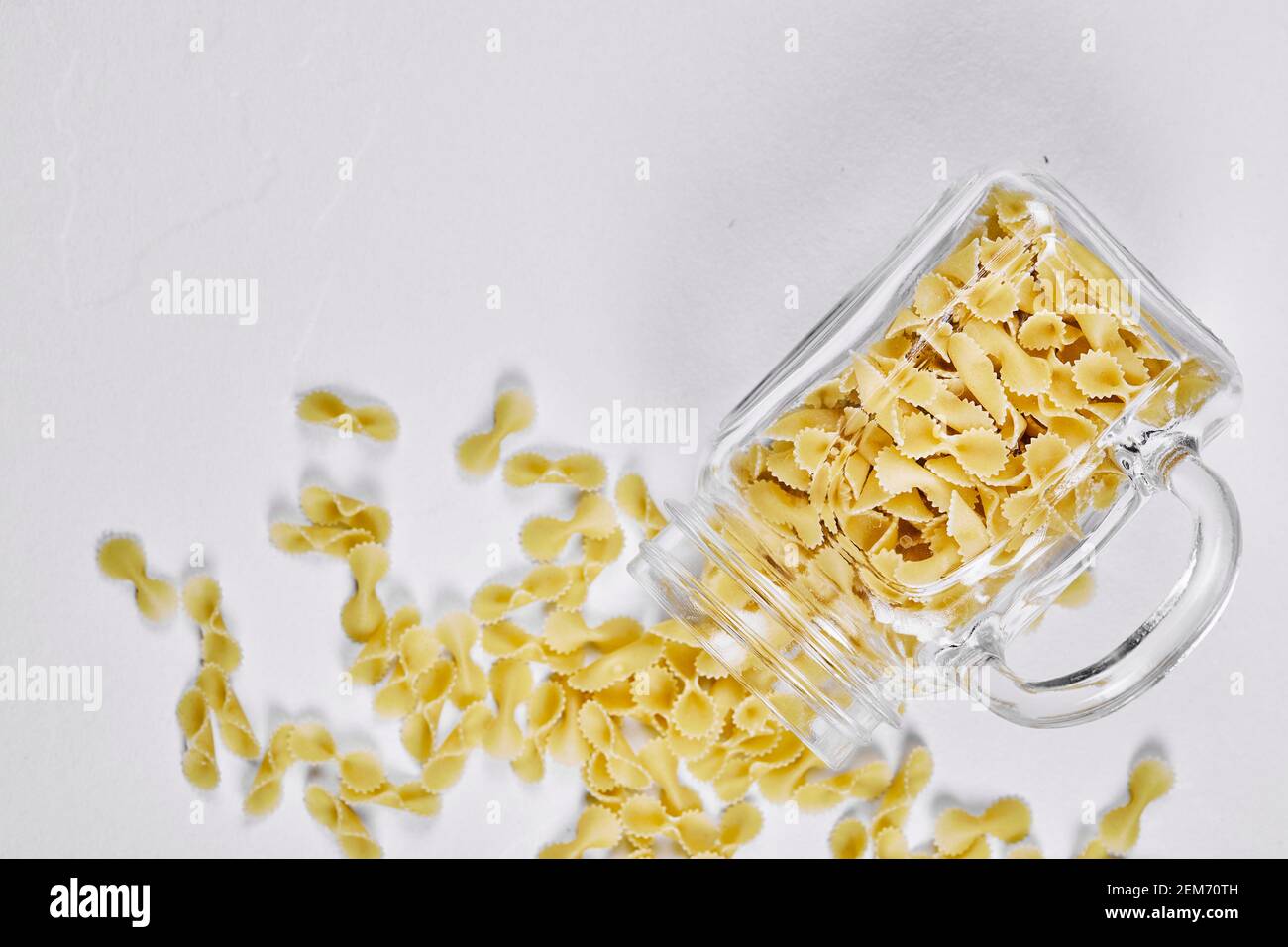 Raw pasta inside the glass jar on white background Stock Photo - Alamy