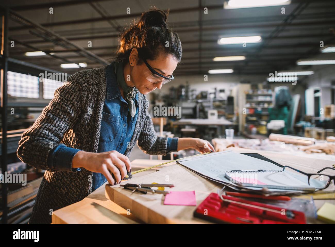 Thoughtful middle-aged industrial female engineer with eyeglasses ...
