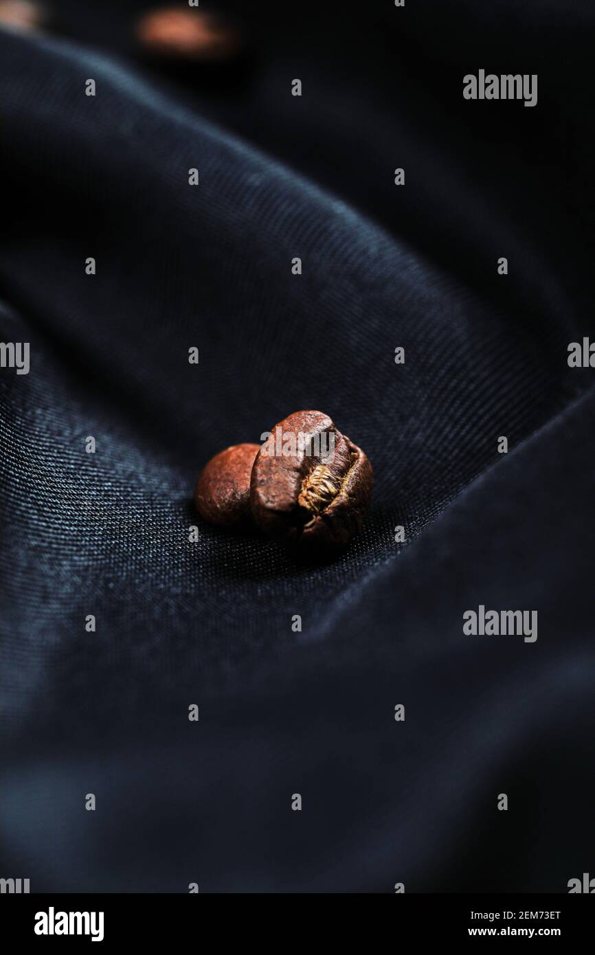 A tiny coffee beans on the dark blue cloth Stock Photo - Alamy
