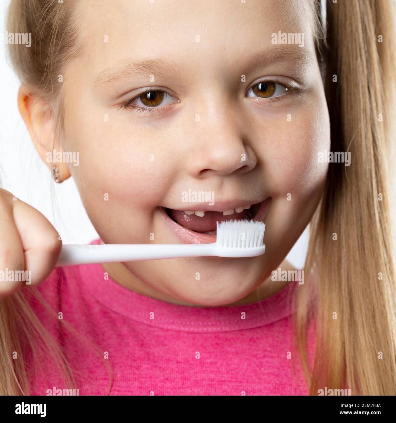 Preschool girl with first adult incisors and a toothbrush. The milk ...