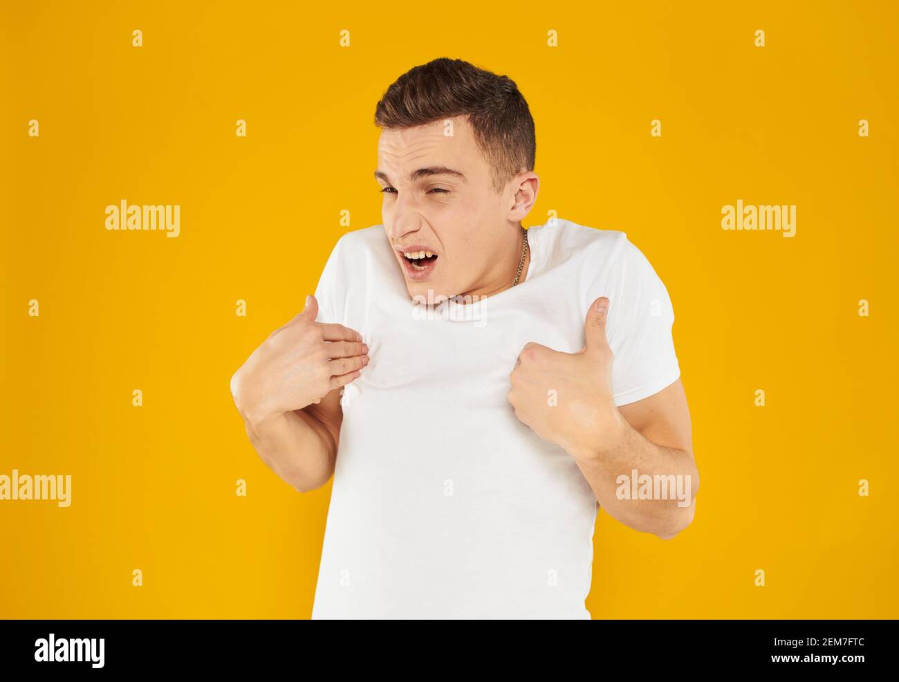 Emotional guy gesturing with his hands near his face on a yellow ...