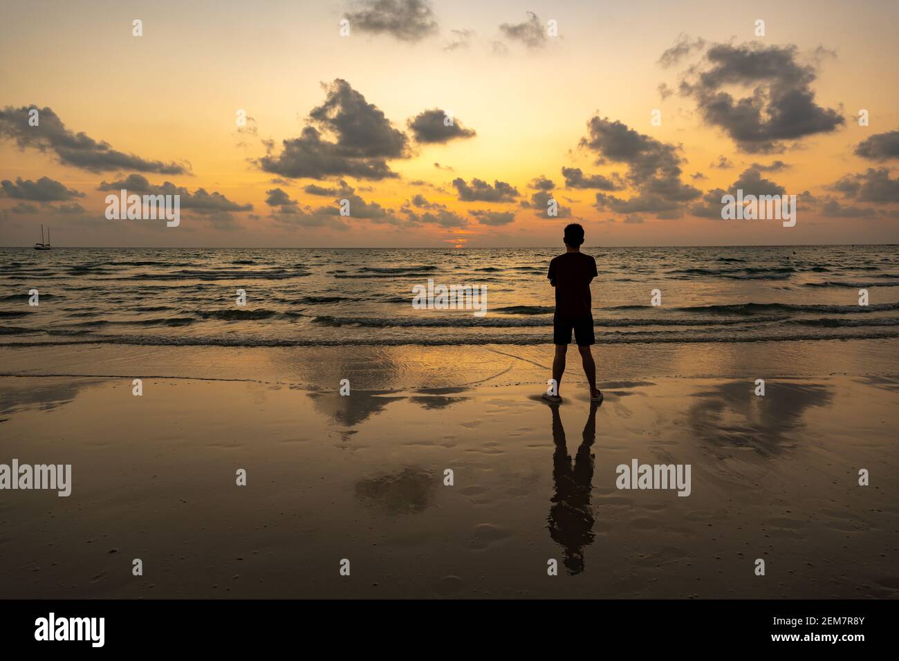 The silhouette of a man by the sea at sunset, at the beach and ...