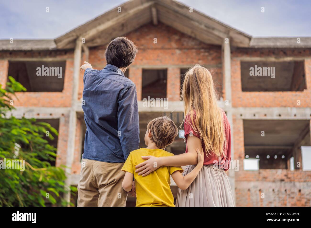 Family mother, father and son looking at their new house under ...