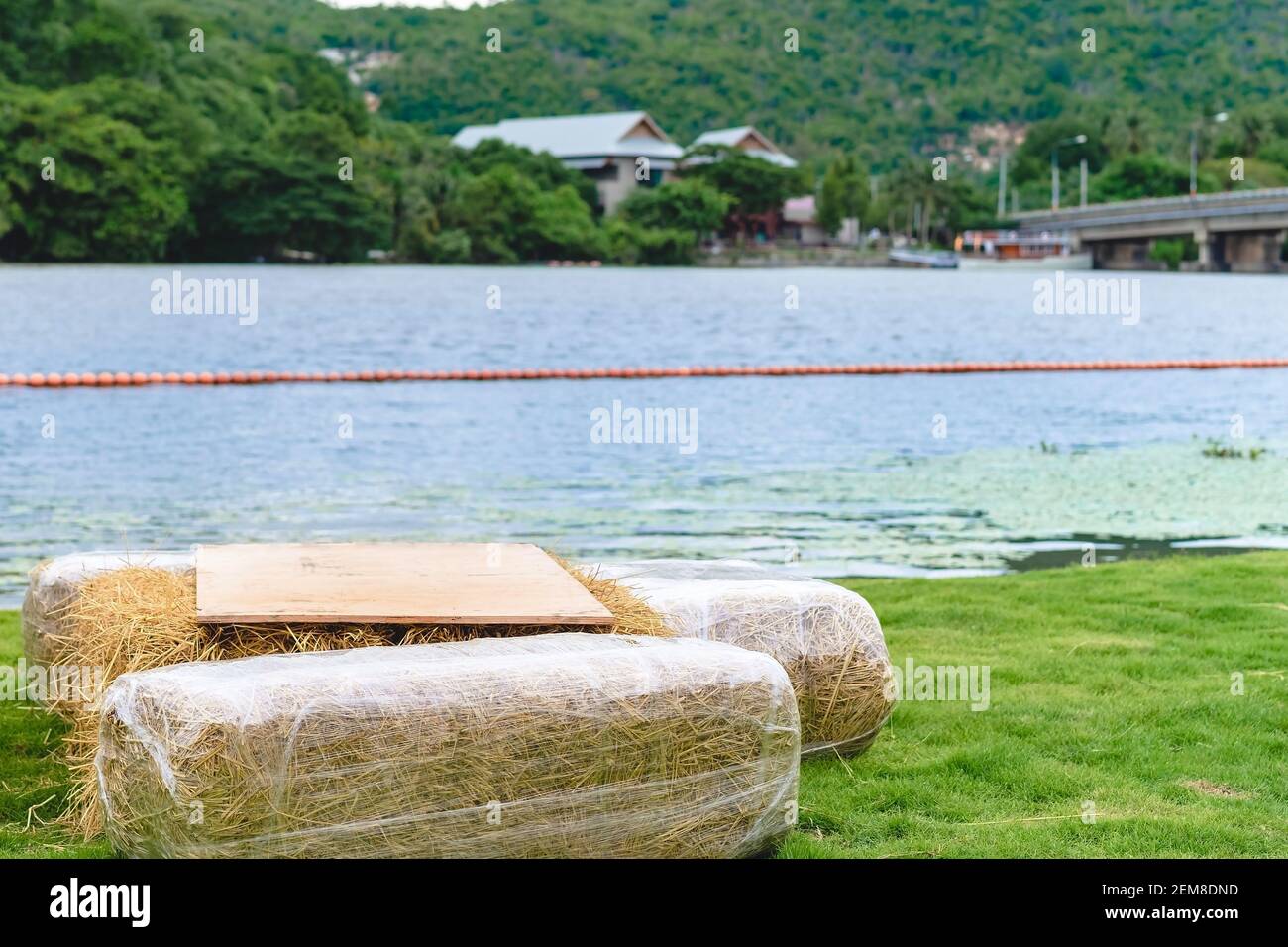 Seats and tables made from straw bales for event and party laid on lawn ...