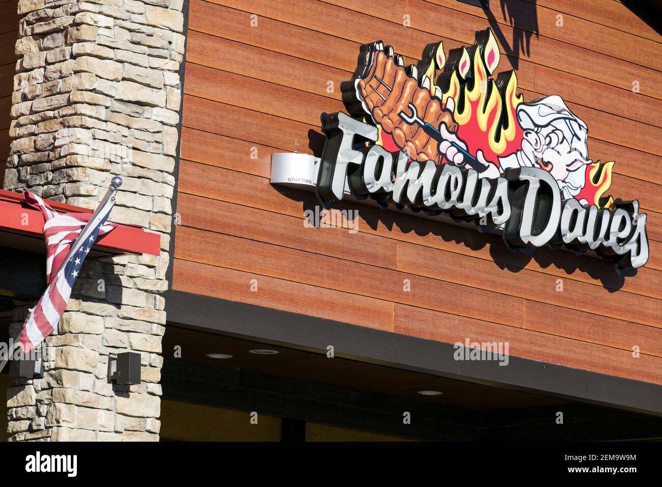 A logo sign outside of a Famous Dave's restaurant location in ...