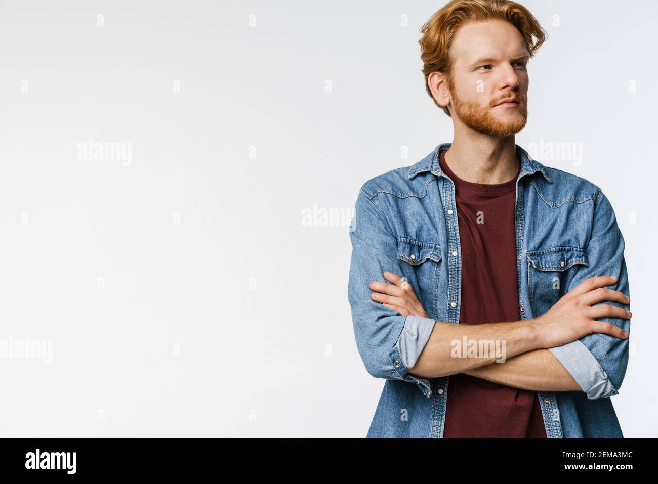 Serious handsome ginger guy posing and arms crossed isolated over white ...