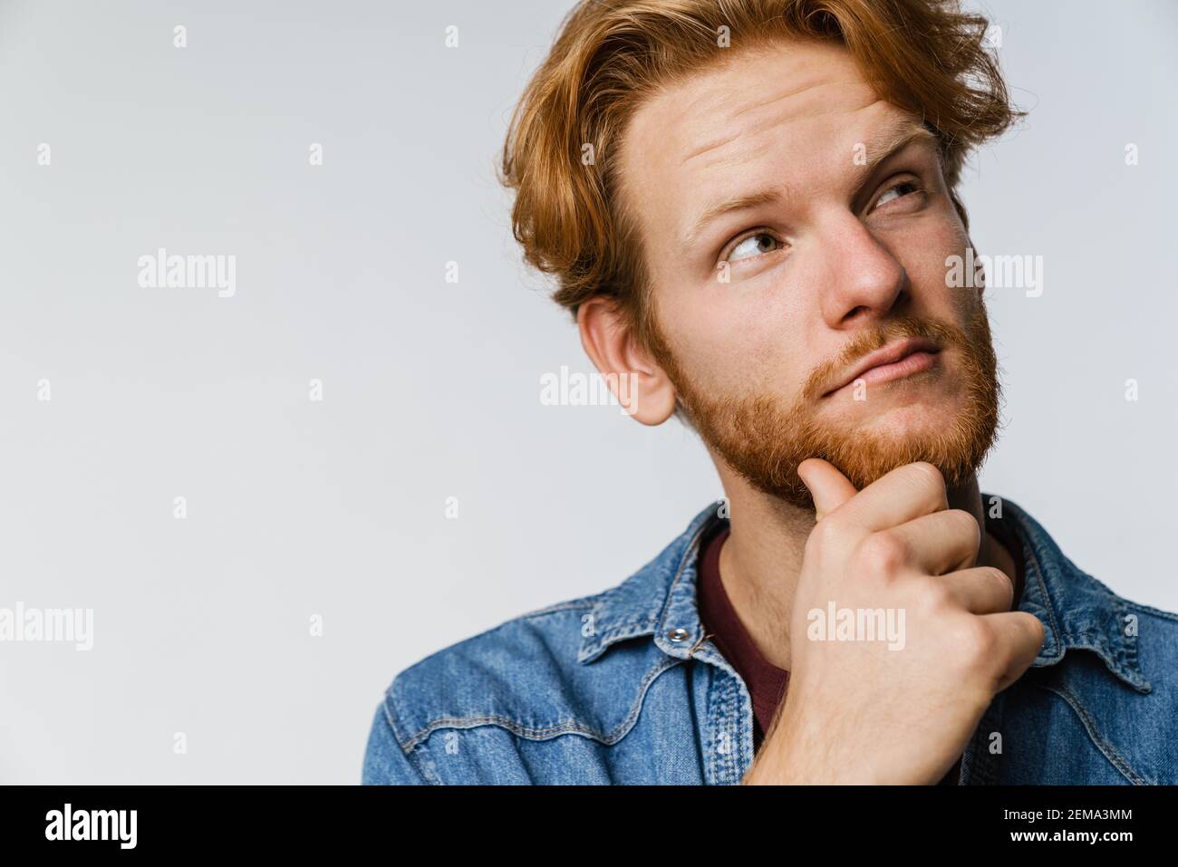 Thinking handsome ginger guy posing and looking upward isolated over ...