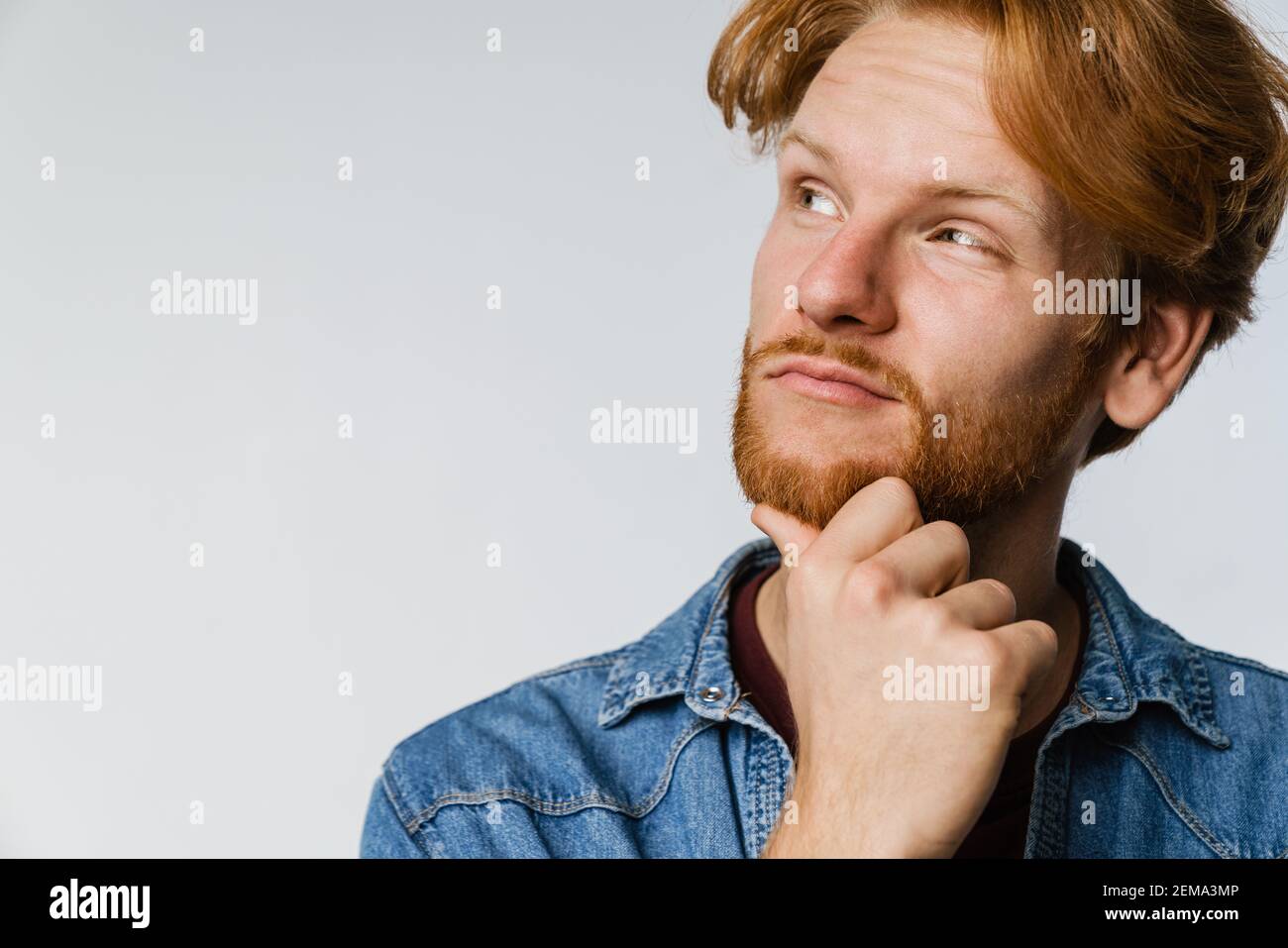 Thinking handsome ginger guy posing and looking upward isolated over ...