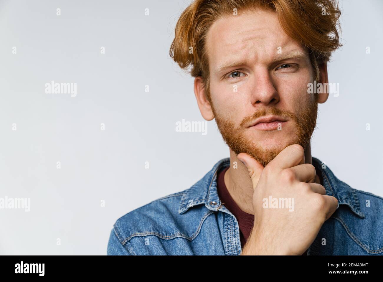 Thinking handsome guy posing and looking at camera isolated over white ...