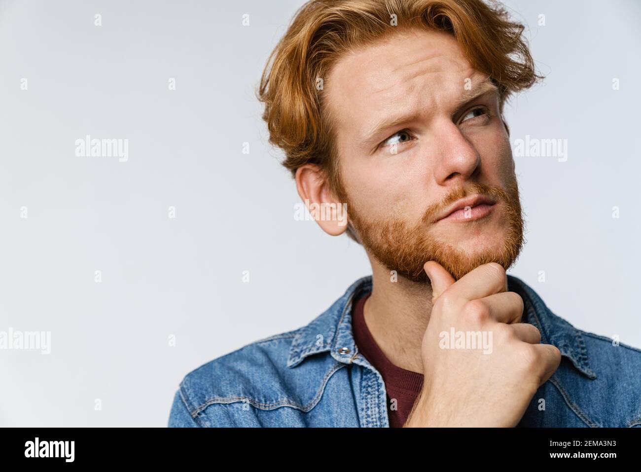 Thinking handsome ginger guy posing and looking upward isolated over ...
