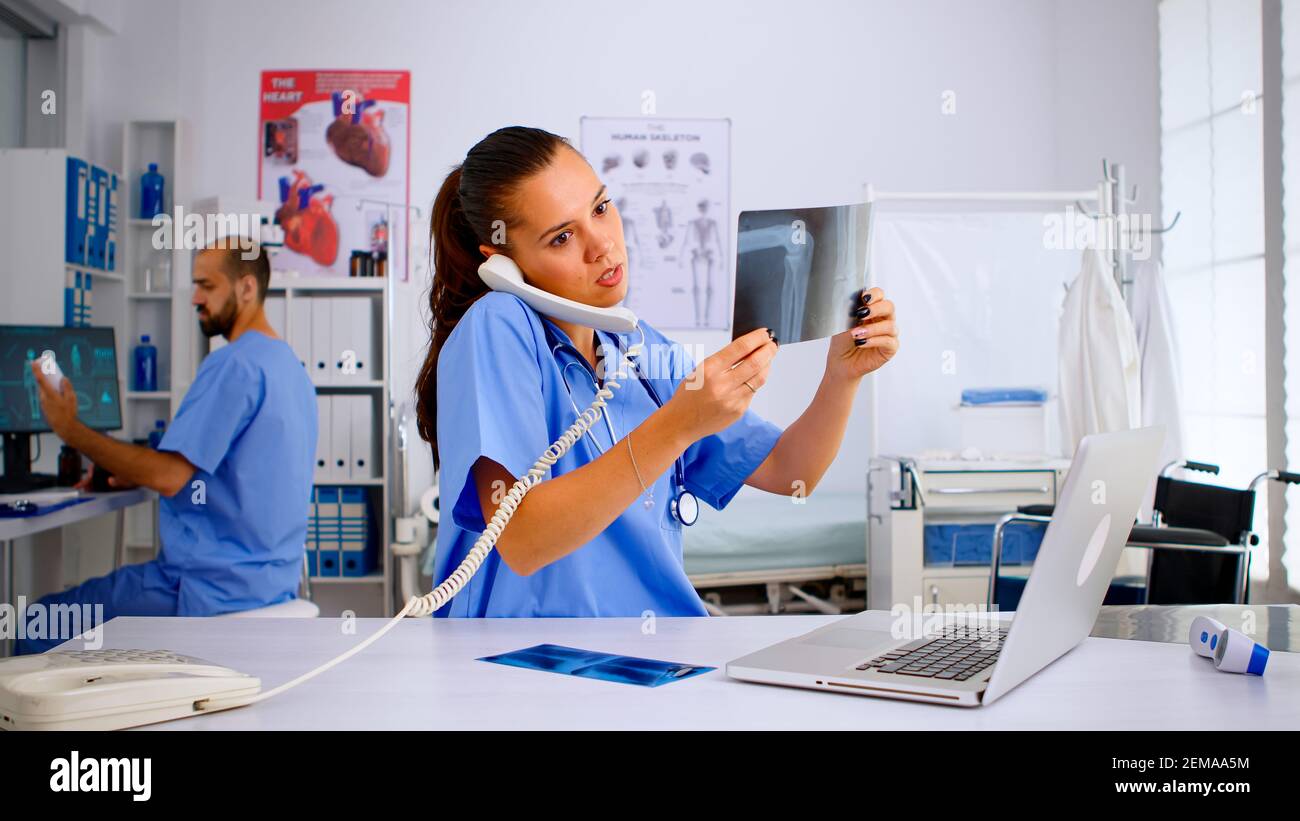 Nurse answering at hospital call checking the result of patient x-ray ...