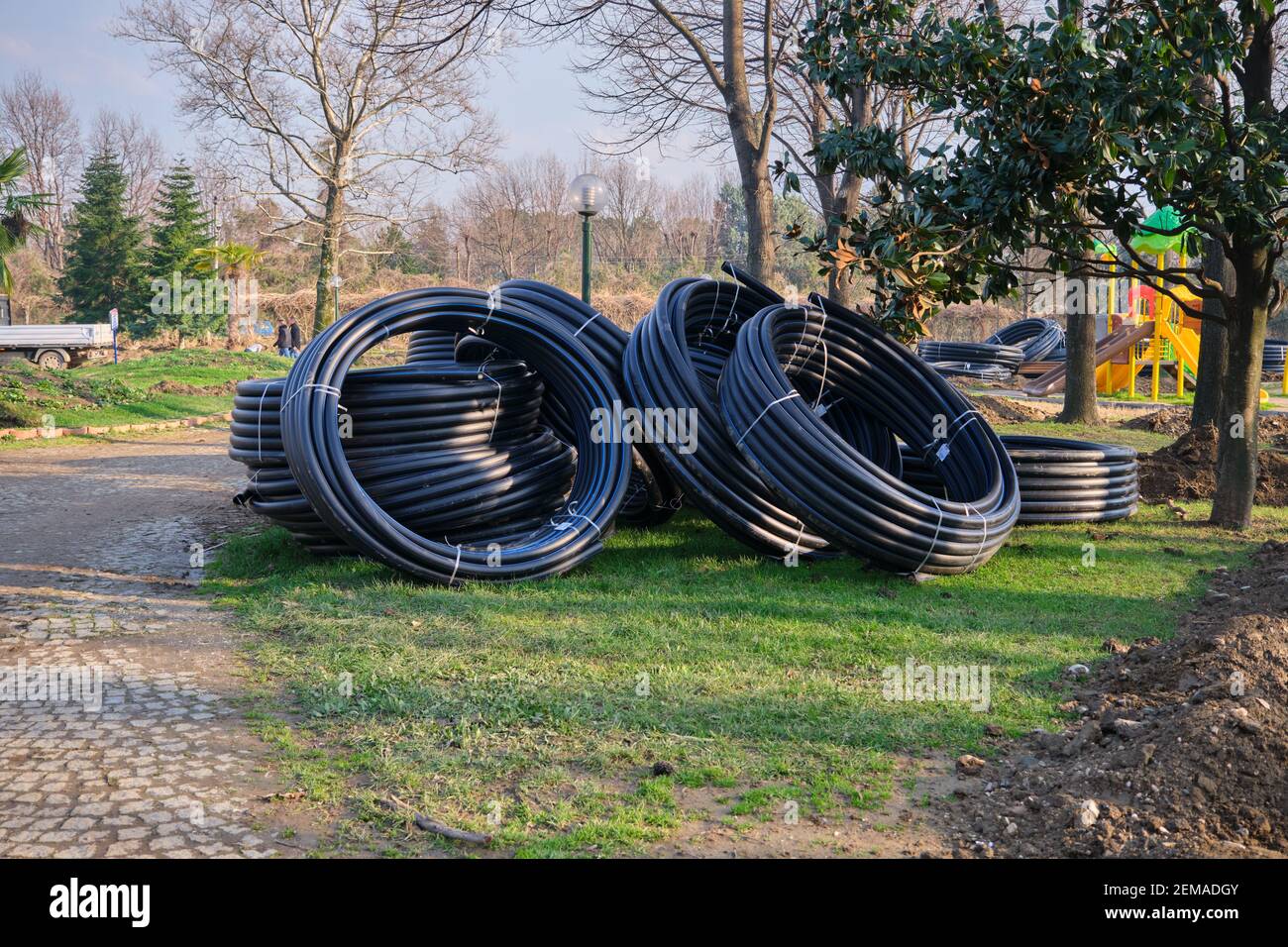 Bunch of black and plastic pipes standing on ground. Pipes for drainage ...