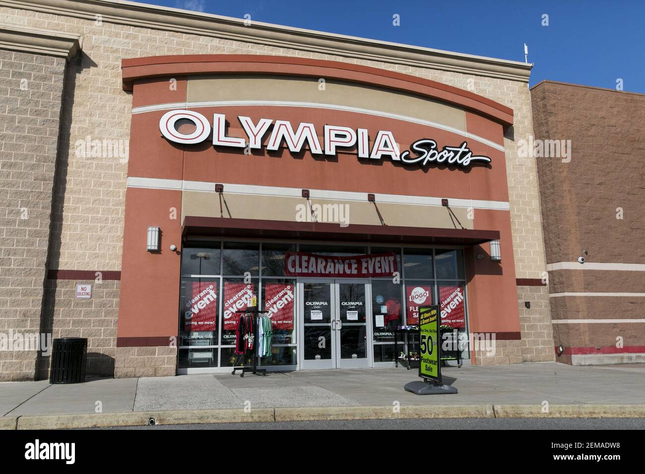 A logo sign outside of a Olympia Sports retail store location in ...