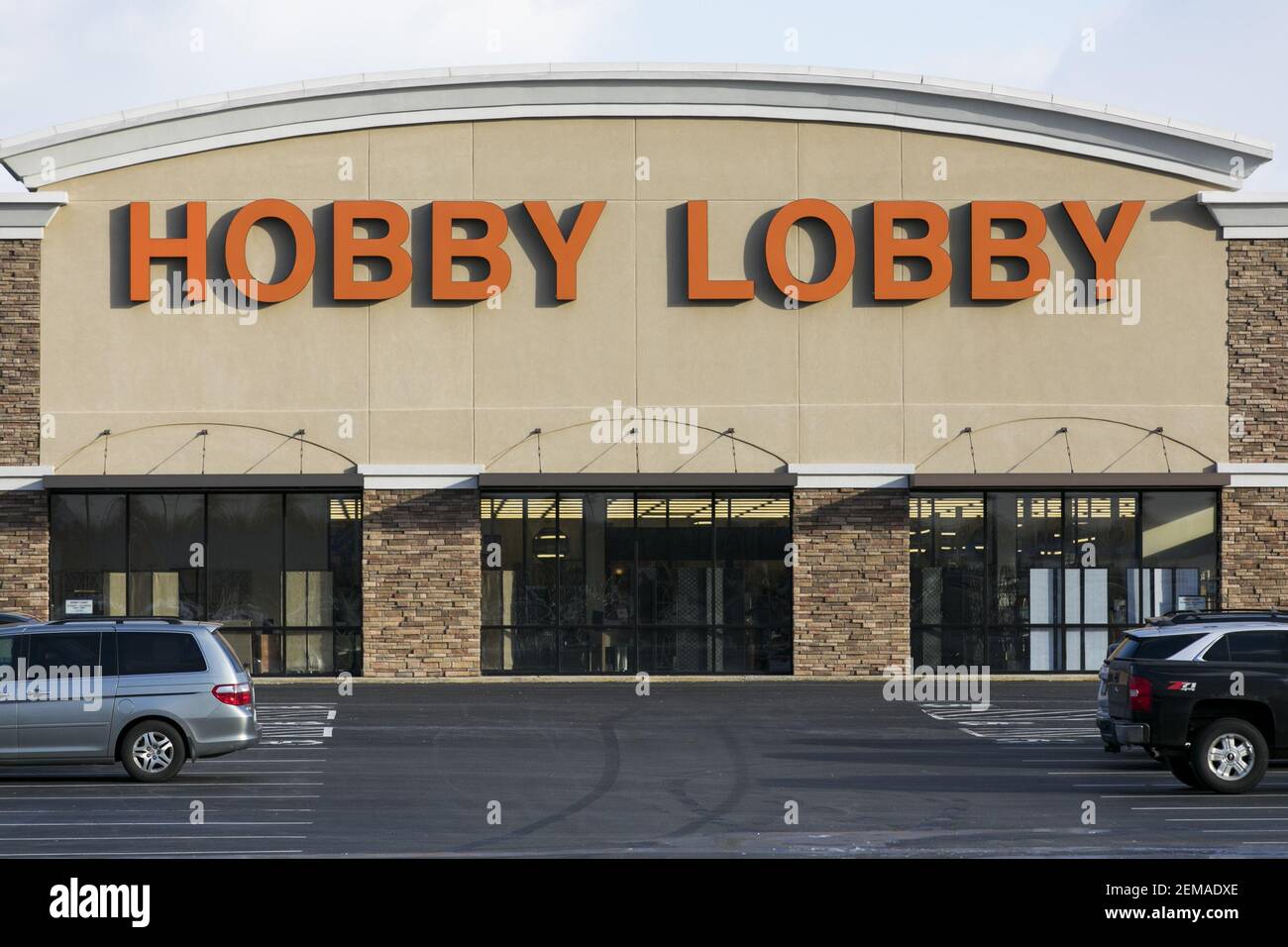 A logo sign outside of a Hobby Lobby retail store location in ...