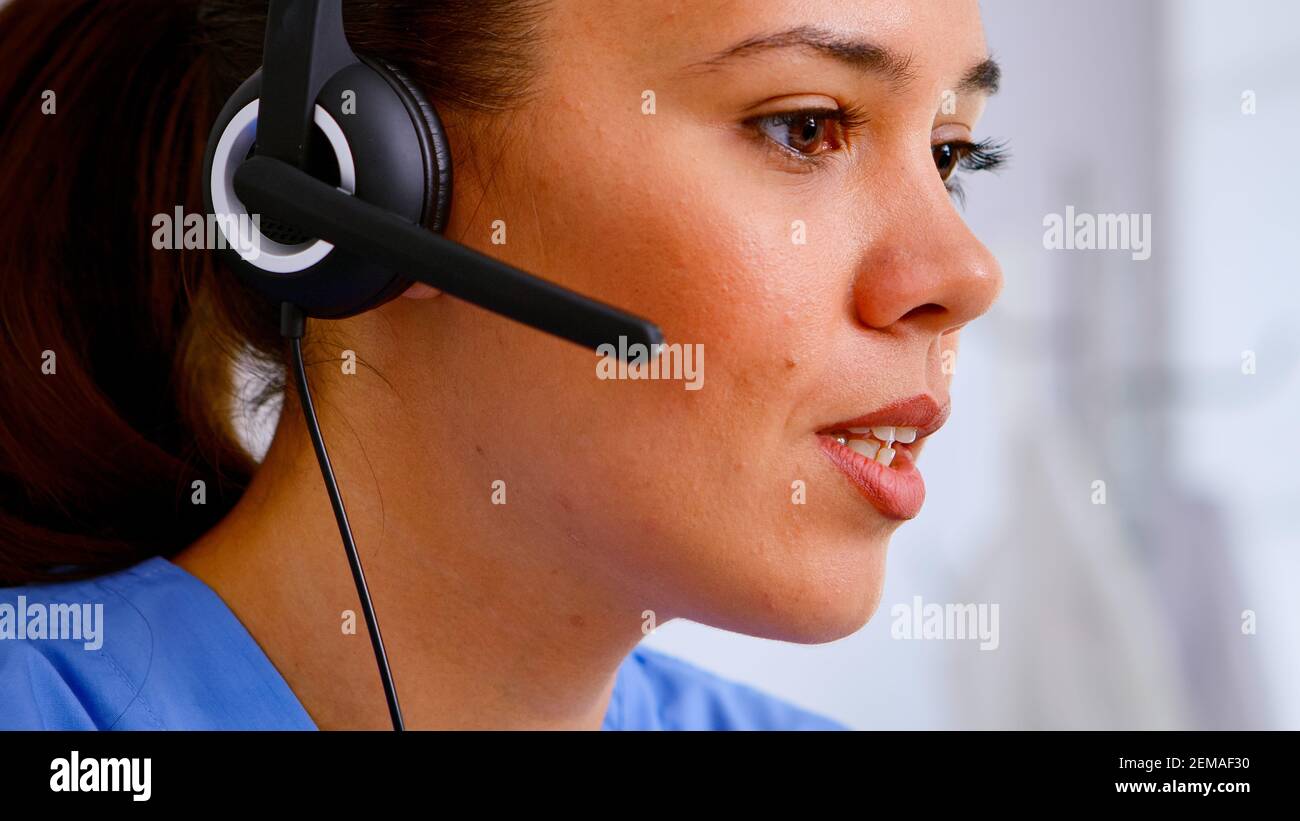 Close up of medical operator with headphone consulting patients during ...