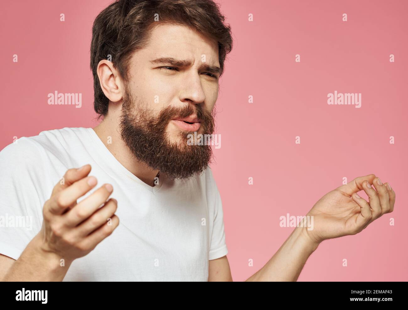 Puzzled man gesturing with hands side view pink background Stock Photo ...