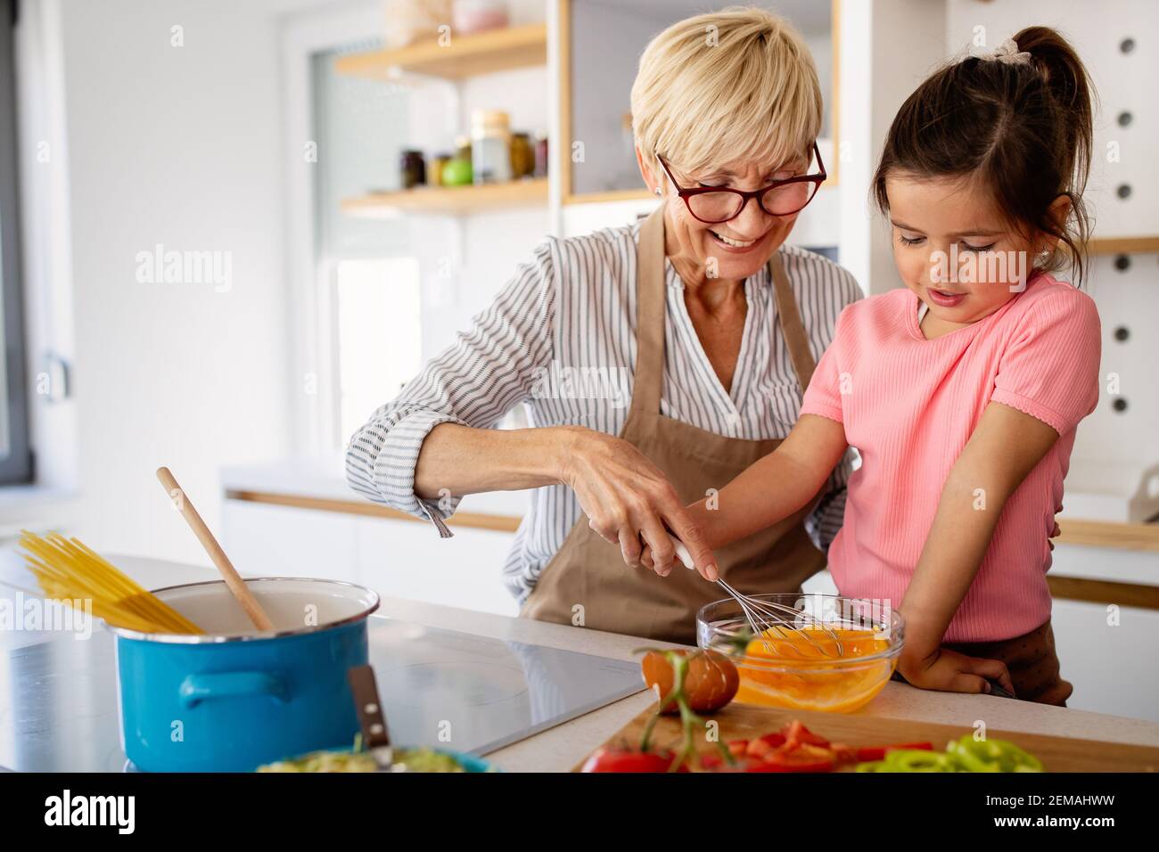 Grandmother and granddaughter are cooking on kitchen. Family fun love ...