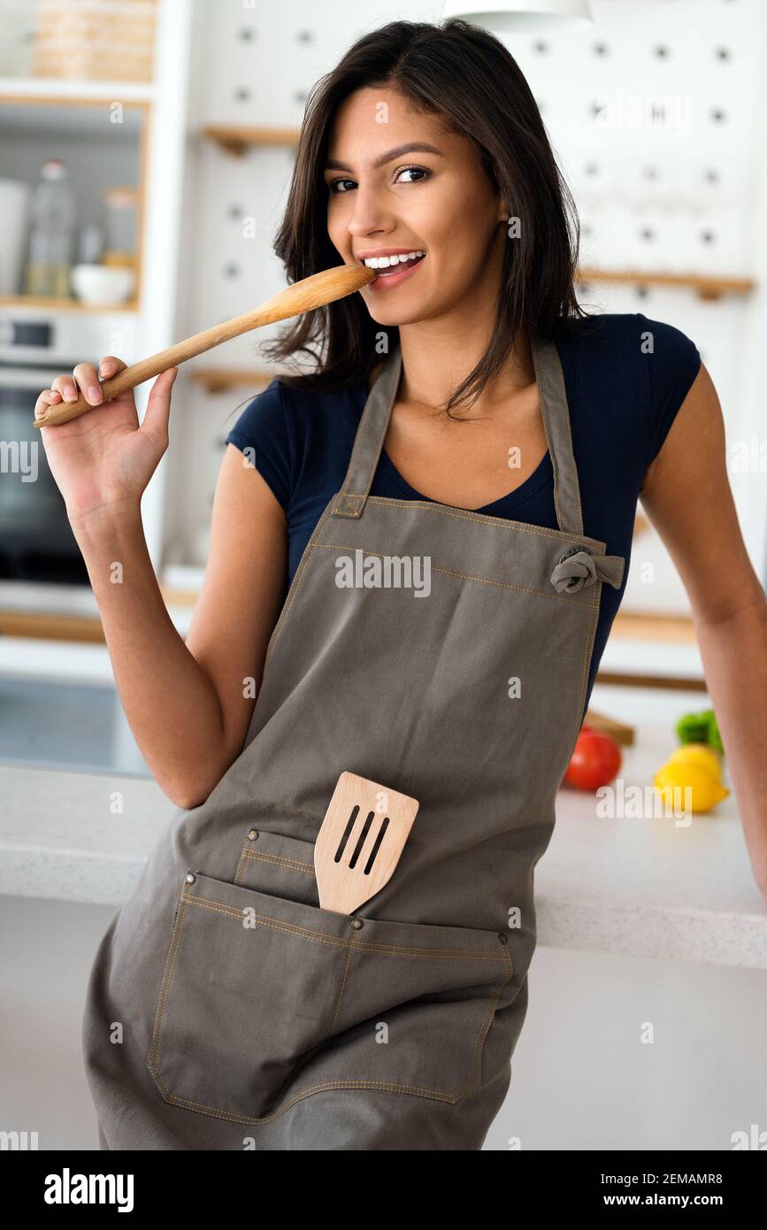 Beautiful woman having fun cooking in kitchen at home Stock Photo - Alamy