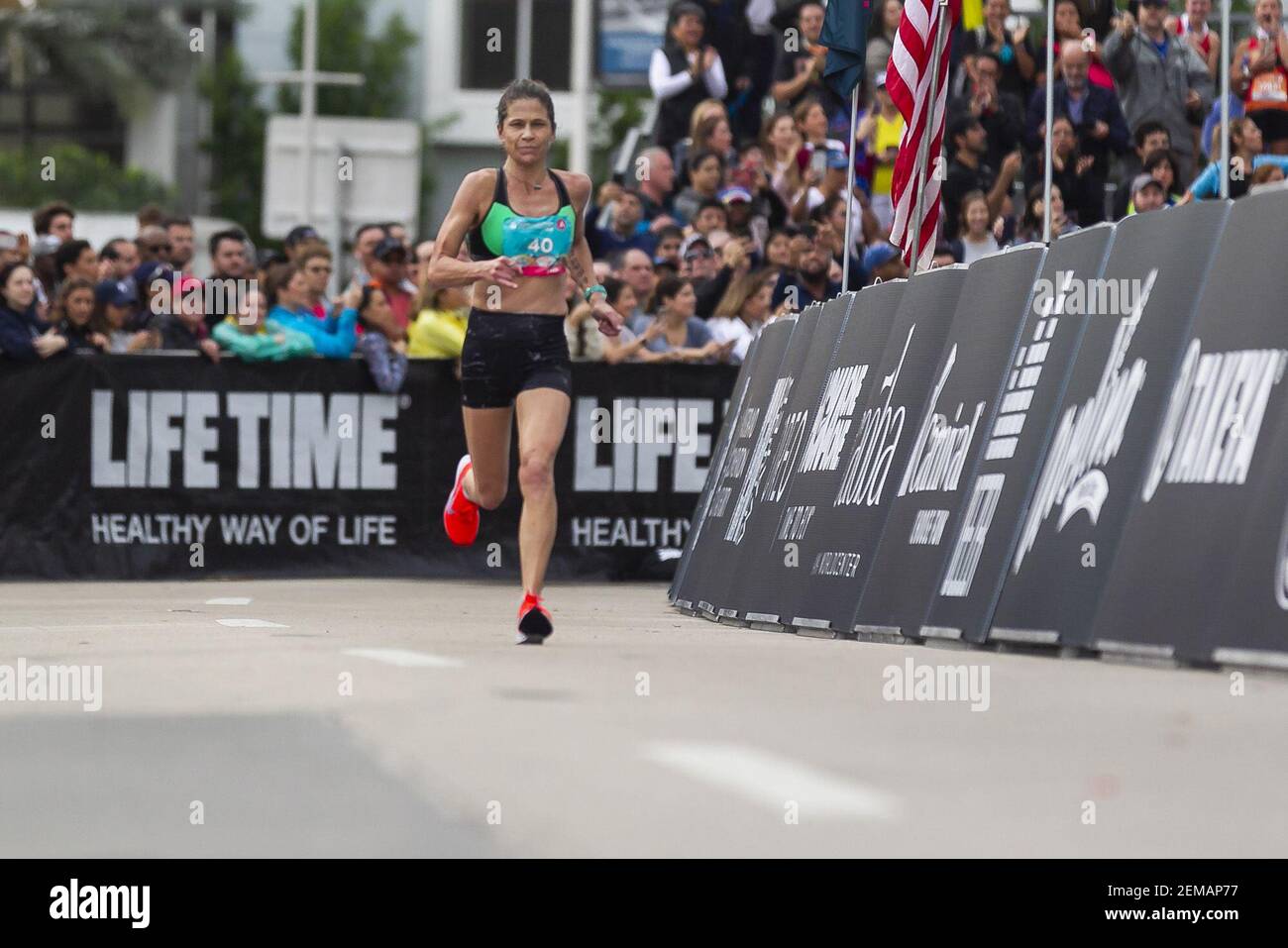 Kate Landau, 42, of Tacoma, Wash., reaches the finish line of the Miami ...