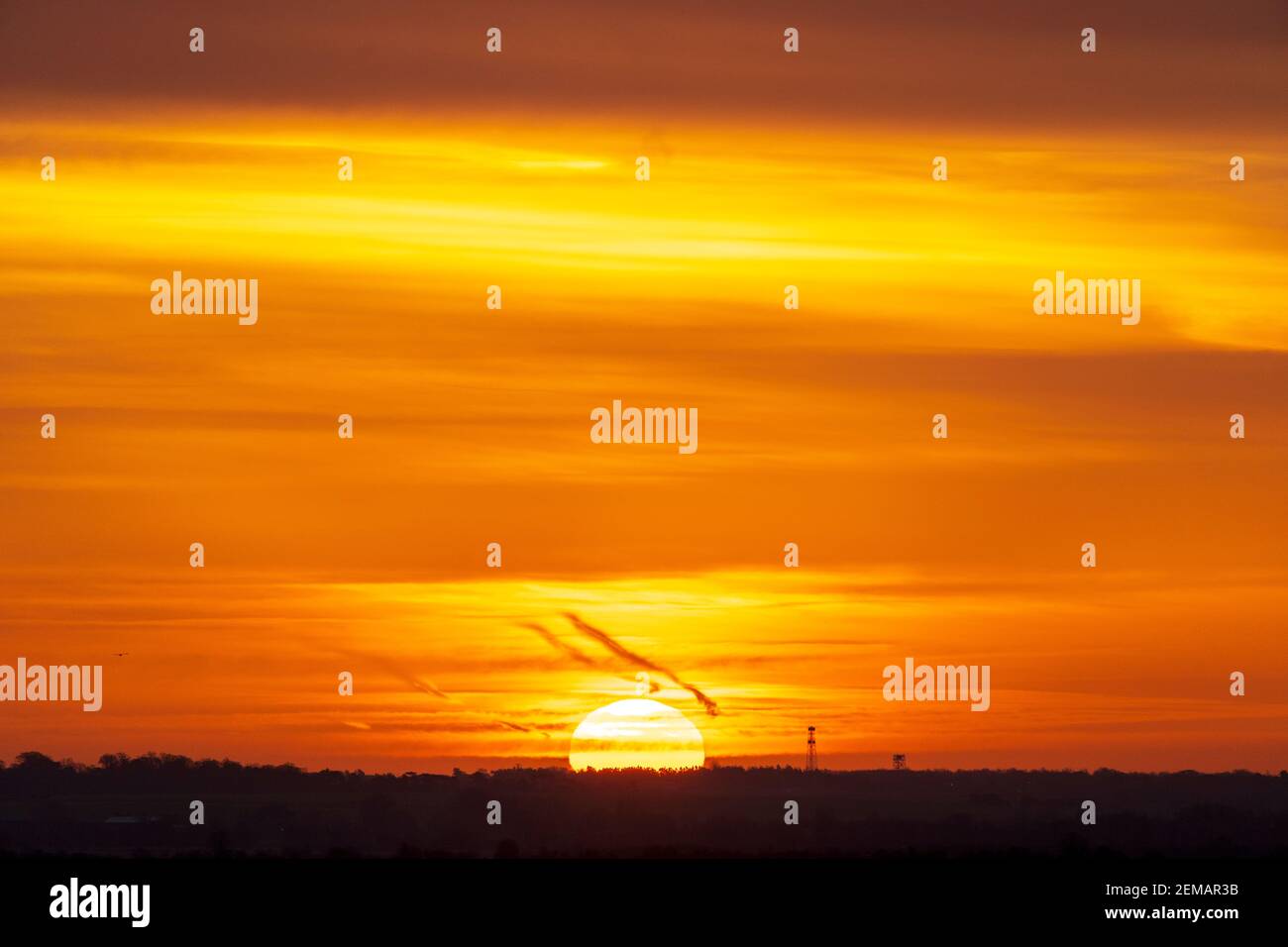 Telephoto view of the sunrise over the Kent landscape. Horizon low in ...