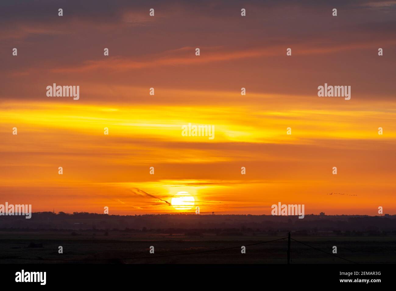 Telephoto view of the sunrise over the Kent landscape. Horizon low in ...
