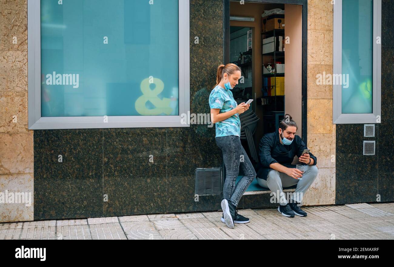Cook and waitress pausing at the back door Stock Photo - Alamy